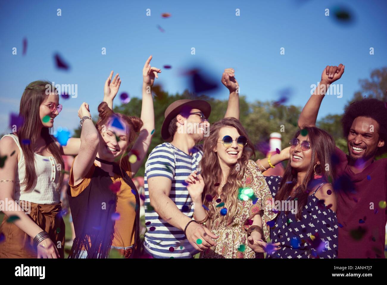 Group of friends dancing in confetti Stock Photo - Alamy