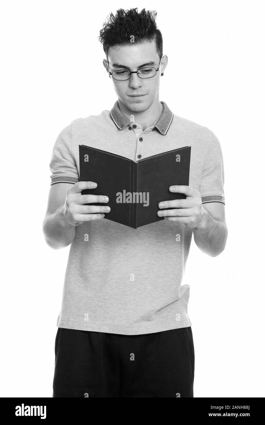 Studio shot of young man reading book Stock Photo - Alamy