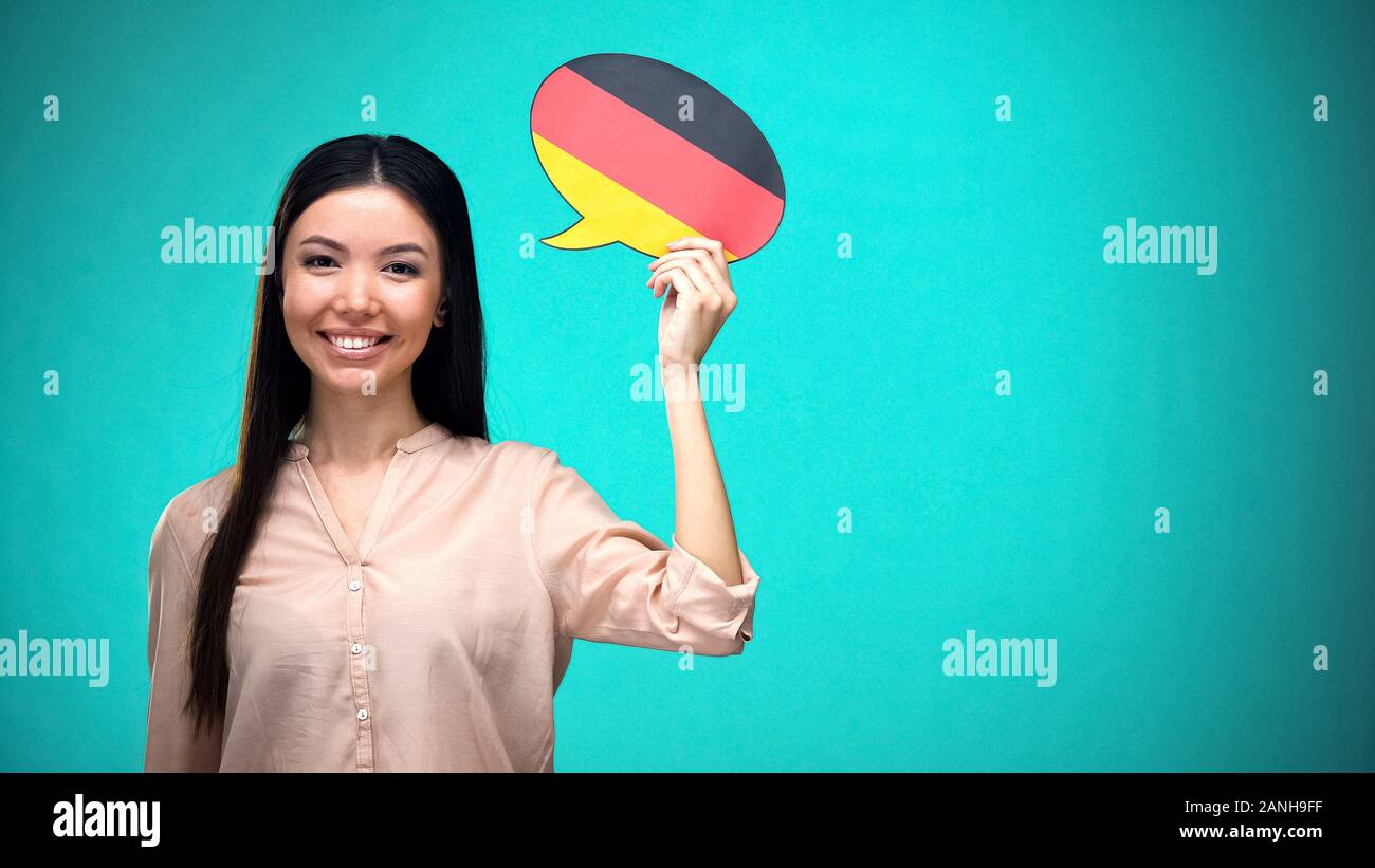 Smiling girl holding German flag speech bubble, learning language ...