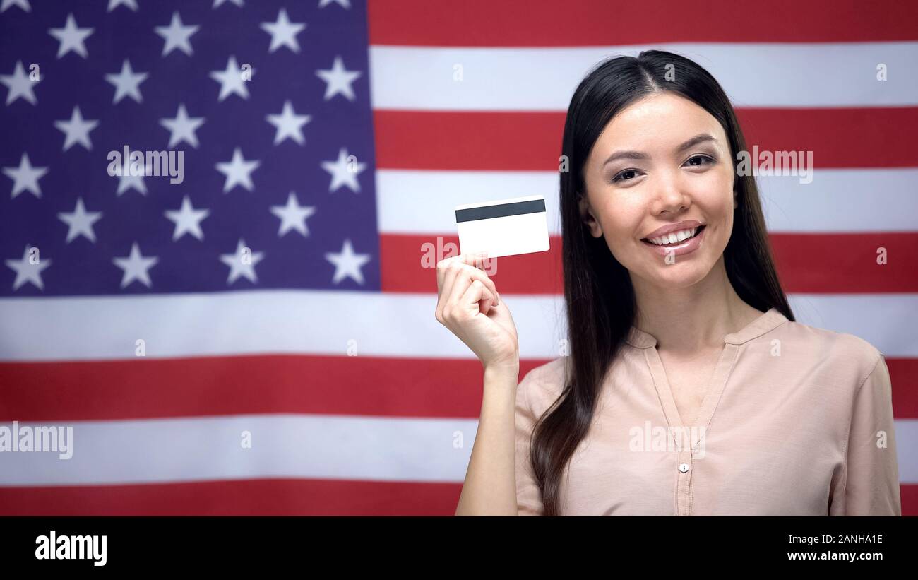 Lady holding credit card against USA flag background, international ...