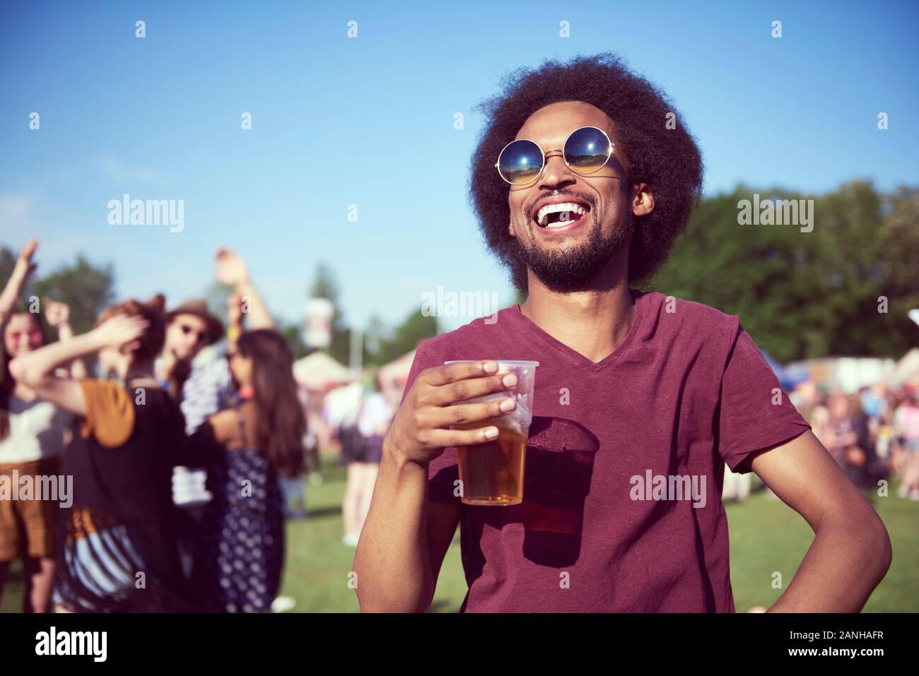 Happy African man drinking beer in festival Stock Photo - Alamy