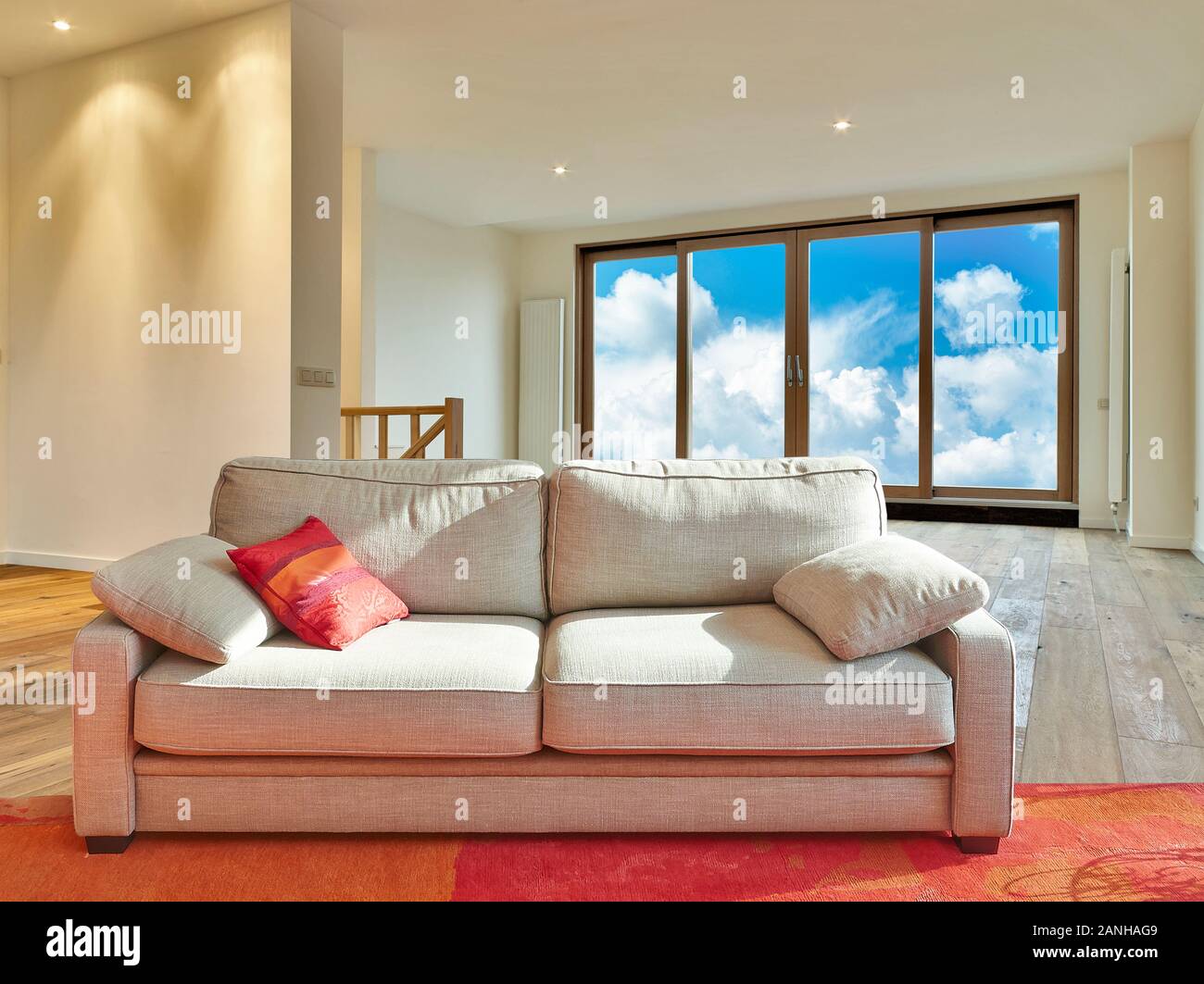 Modern interior with wooden floor and big sofa from front Stock Photo ...