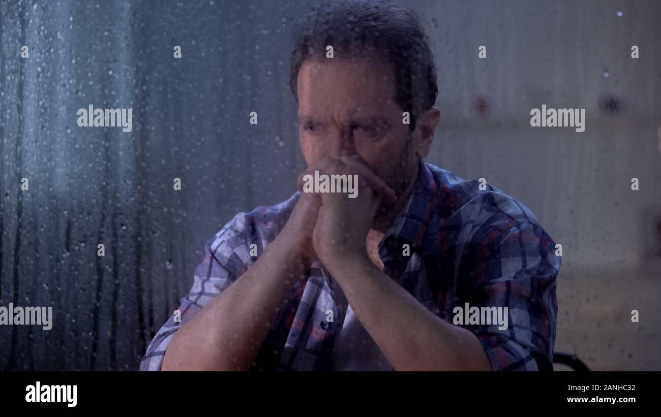 Hopeless man thinking about life and health problems on rainy day ...