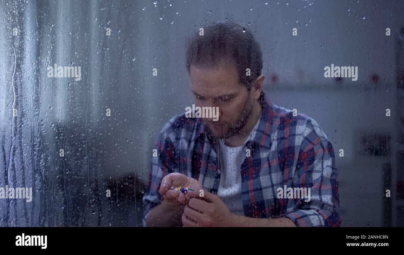 Male war victim holding pills in palm, treating post-traumatic disorder ...