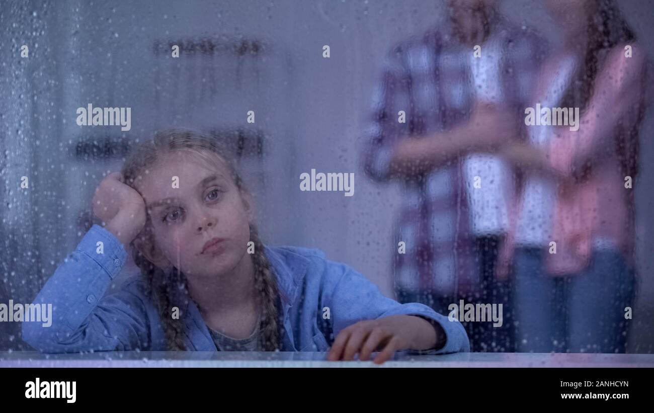 Unhappy little girl behind rainy window, foster parents coming to adopt ...
