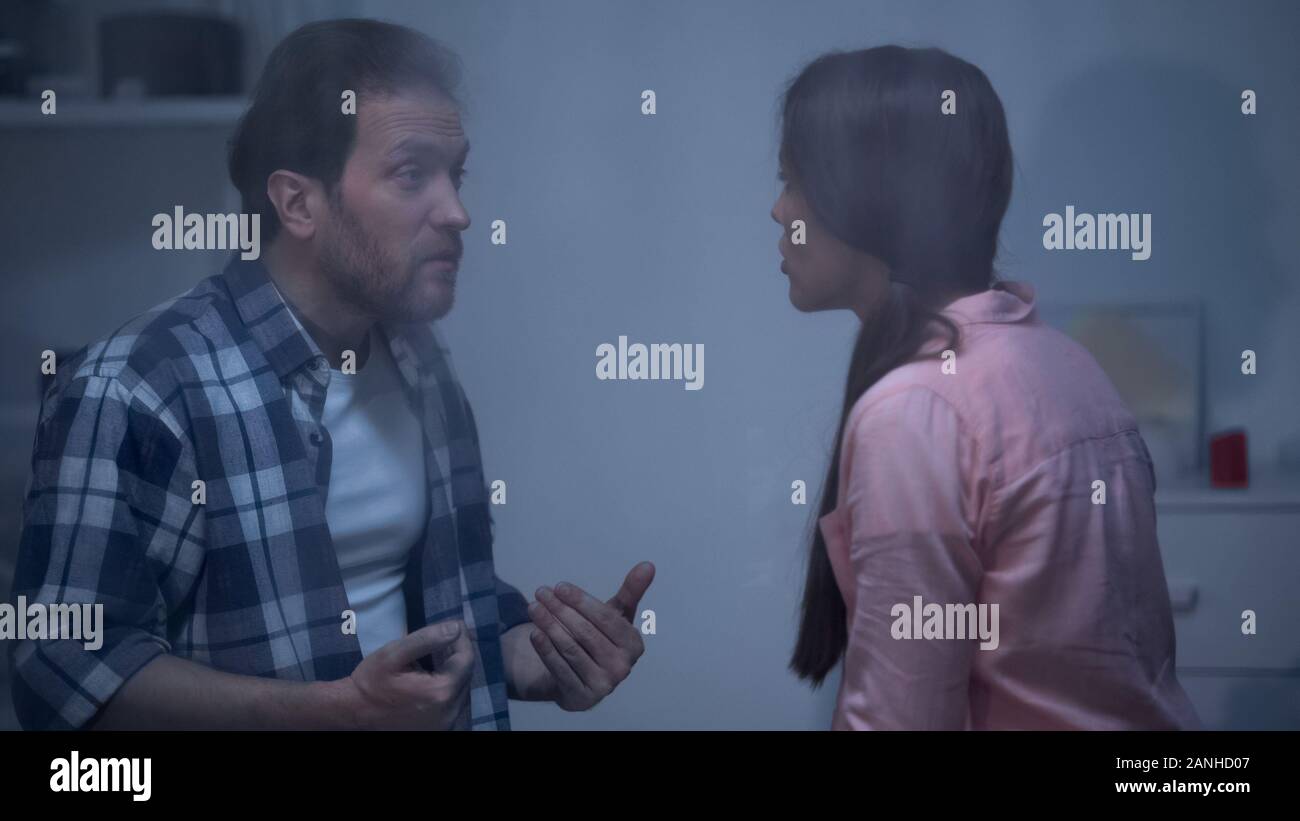 Angry man and woman quarrelling at home behind window, misunderstanding ...