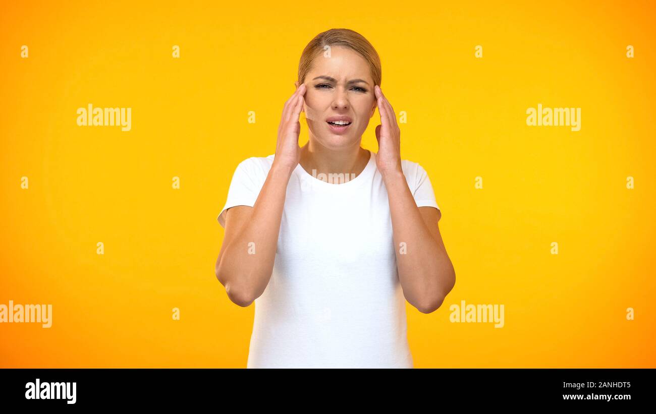 Young lady feeling headache on bright background, temple spasm, health ...