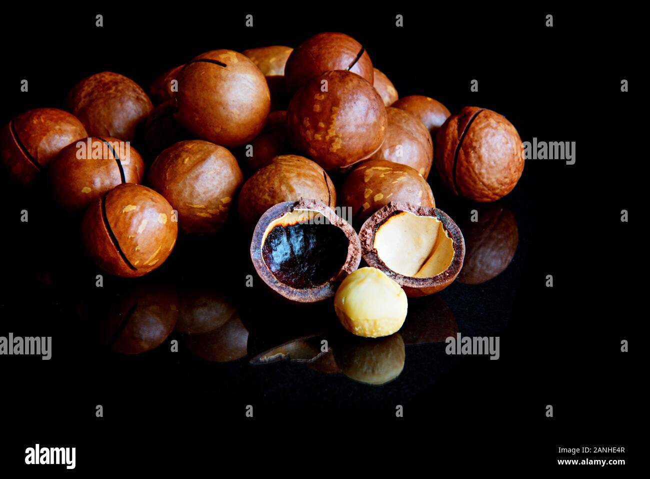 Peeled and unpeeled macadamia nuts on a black background Stock Photo ...