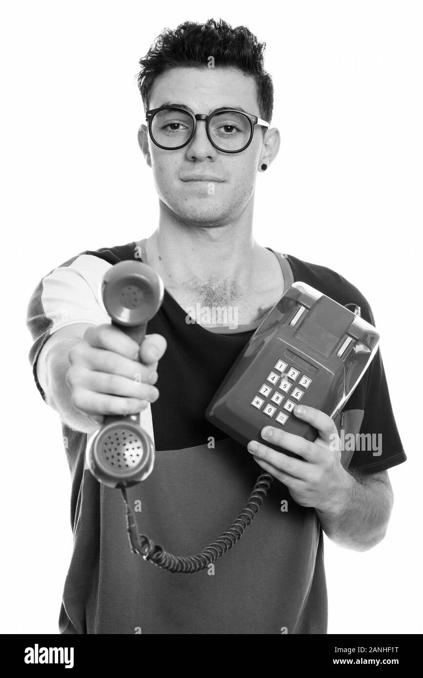 Studio shot of young man giving old telephone Stock Photo - Alamy