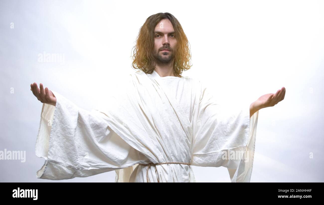 Good God in white robe looking at camera, raising hands to give hope ...