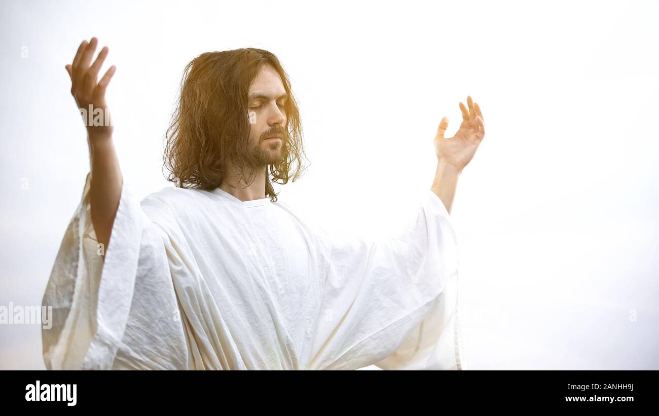 Jesus raising hands illuminated with light, resurrection and ascension ...