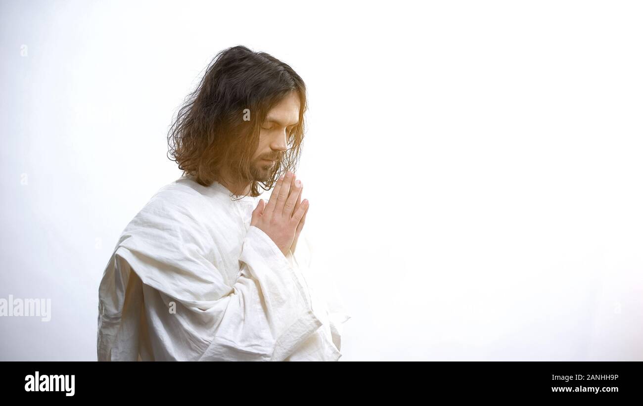 Religious man praying to God, light falling as sign of forgiveness, God ...