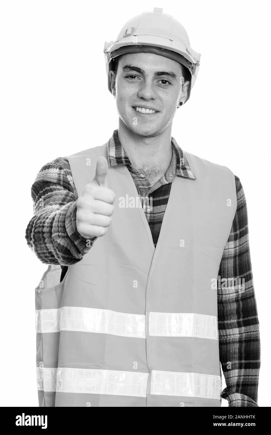 Studio shot of happy young man construction worker smiling while giving ...