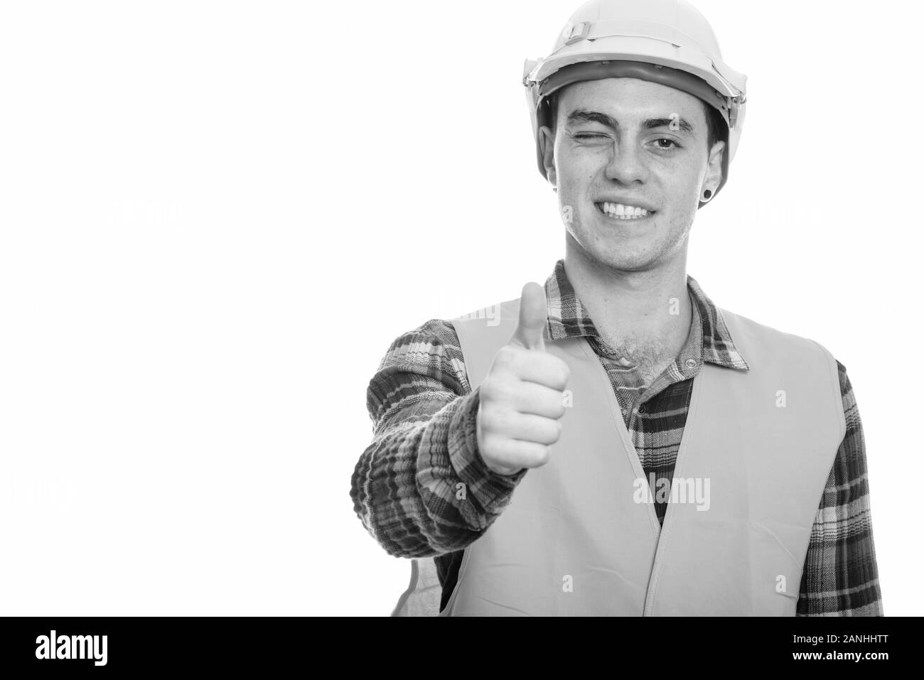 Happy young man construction worker smiling while giving thumb up and ...