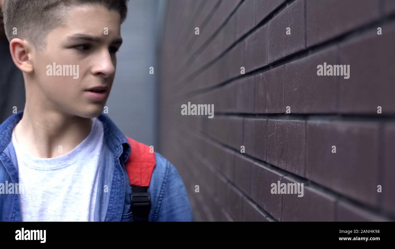 Boy with fear looking at wall as symbol of life obstacles ...