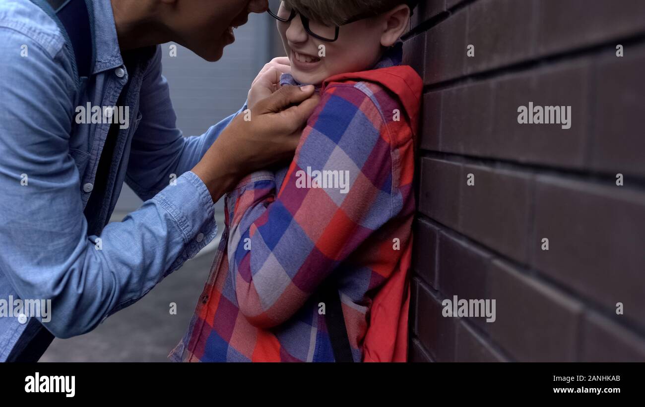 Aggressive teen boy bullying weak nerd, intimidating with physical ...
