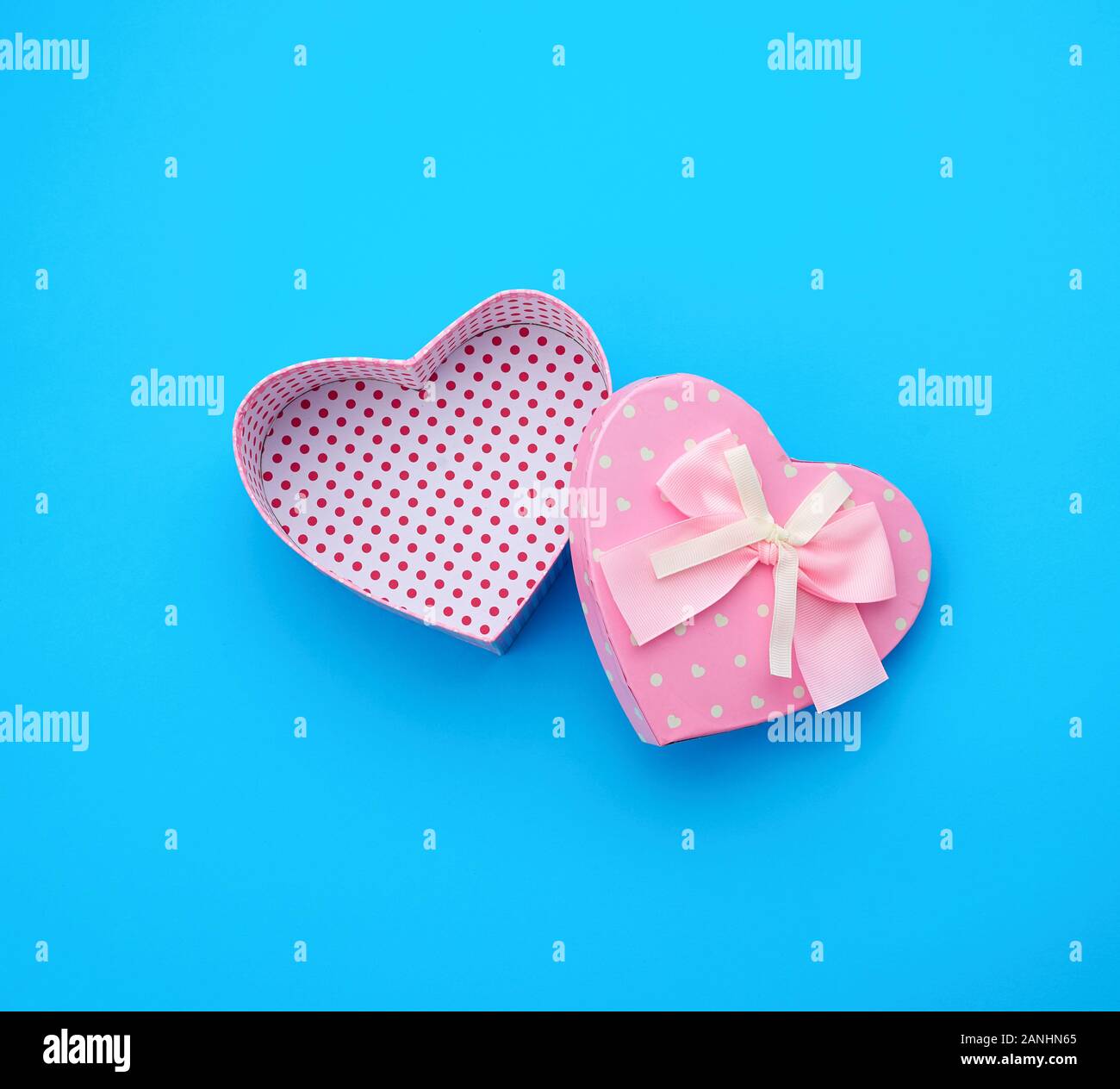 open empty cardboard box in the form of a heart on a light blue ...