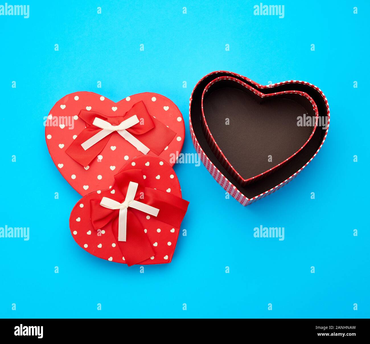 open empty red cardboard box in the form of a heart on a light blue ...