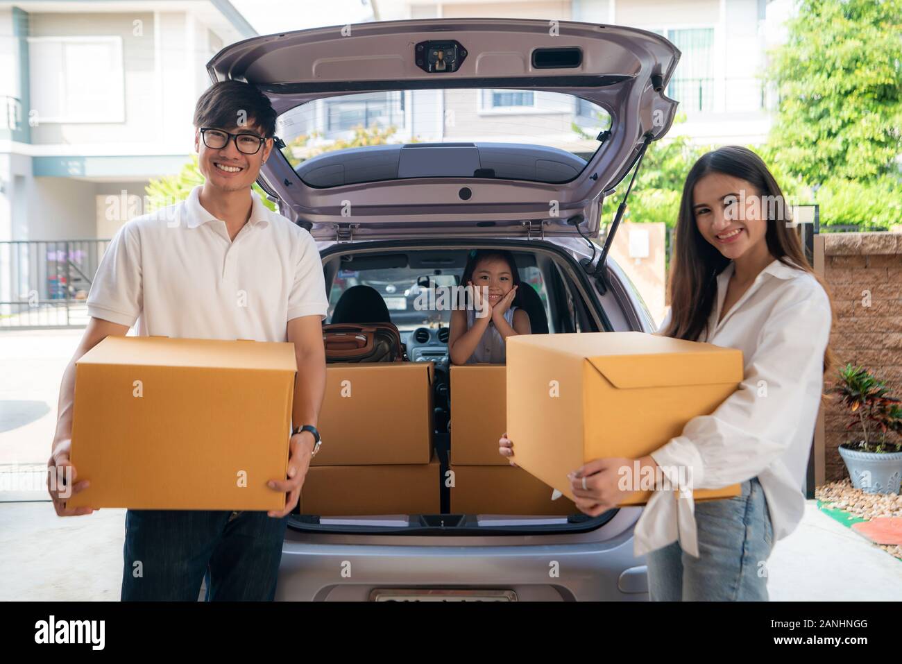 Happy Asian family with father and mother is standing near car with ...