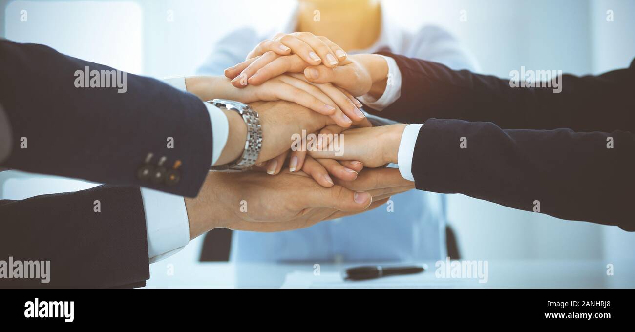Business team showing unity with their hands together in sunny office ...