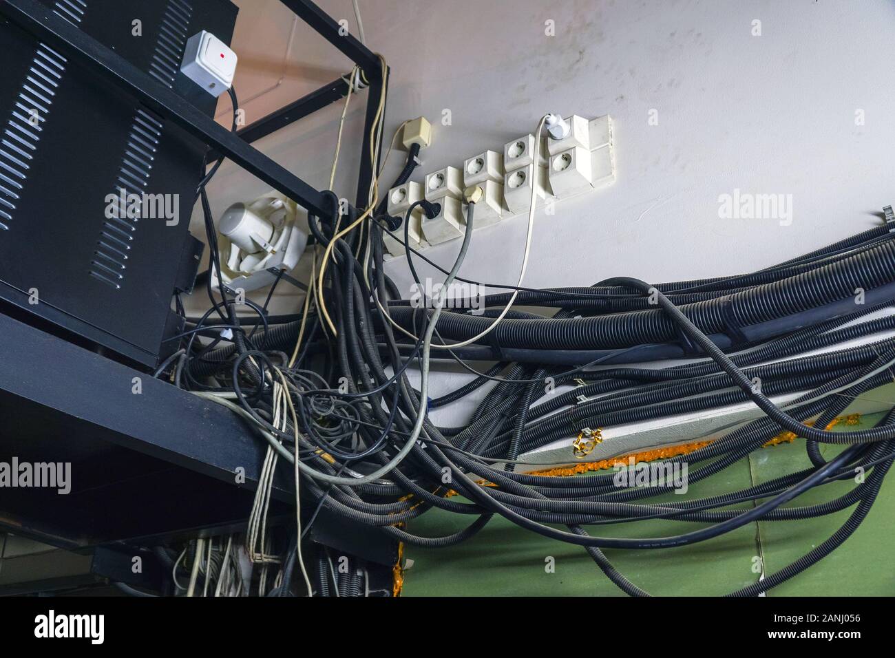 Lots of different cables hanging in a mess on the wall. Poor cable ...