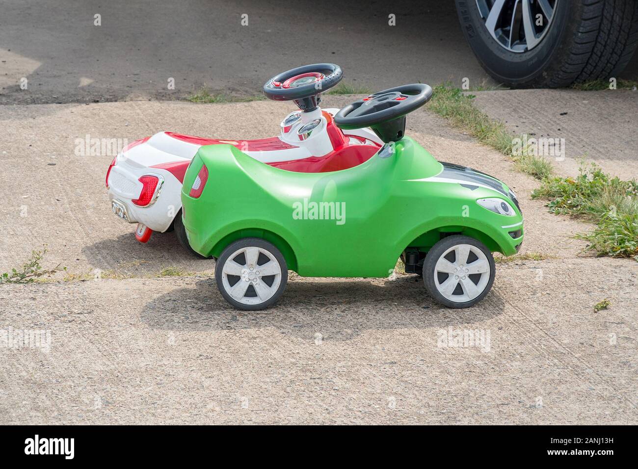 Modern children's plastic cars in the park Stock Photo - Alamy