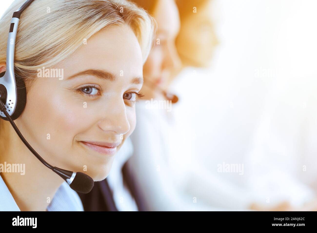 Group of diverse phone operators at work in sunny office. Handsome ...