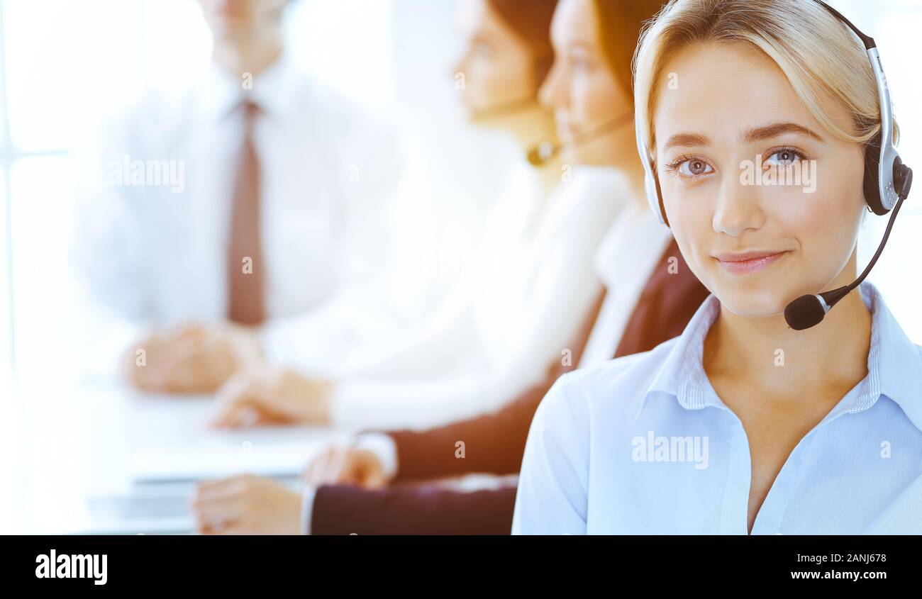 Group of diverse phone operators at work in sunny office. Handsome ...