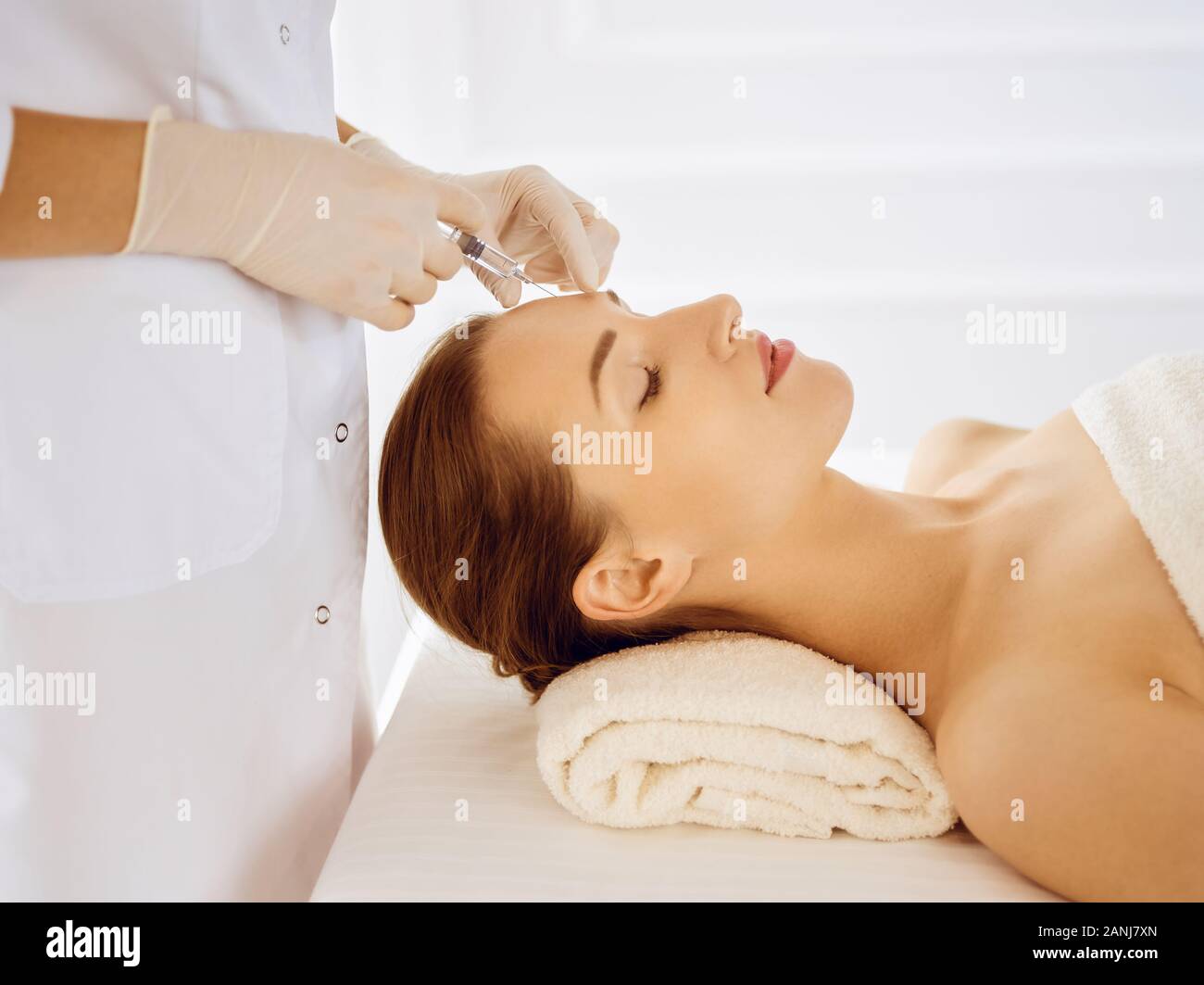 Beautiful woman receiving beauty injections with closed eyes ...
