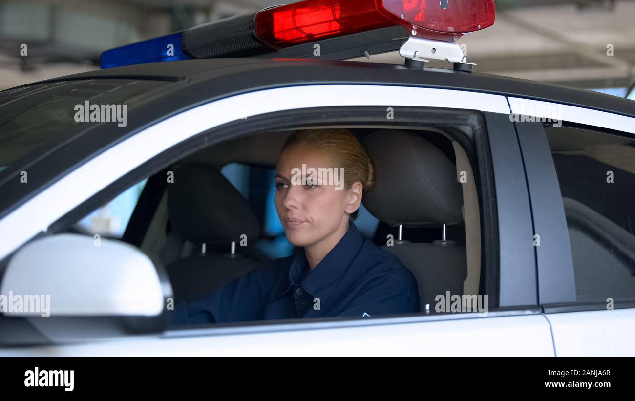 Female police officer sitting frustrated in patrol car after night ...