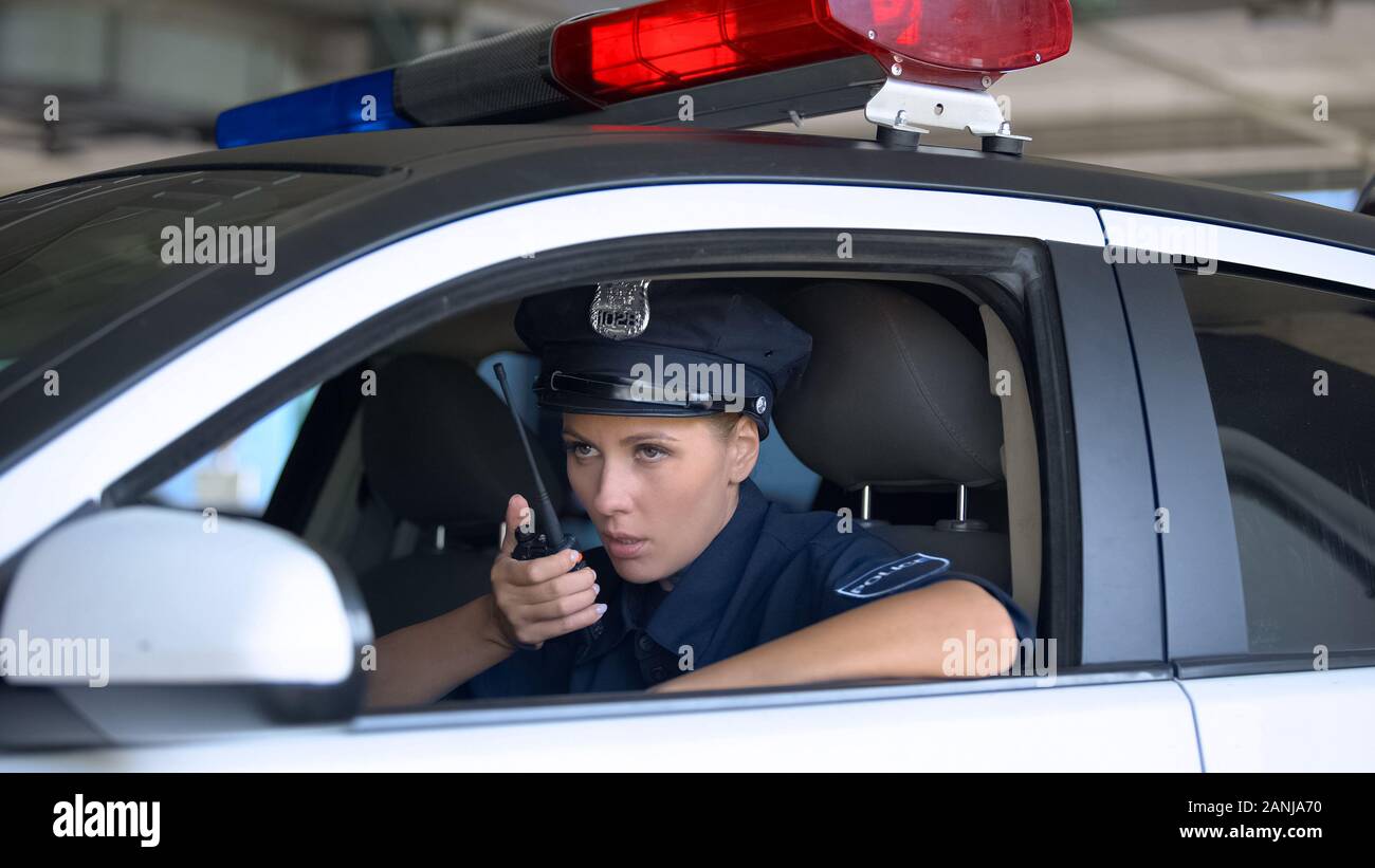 Female cop talking on walkie-talkie, responding emergency call, crime ...