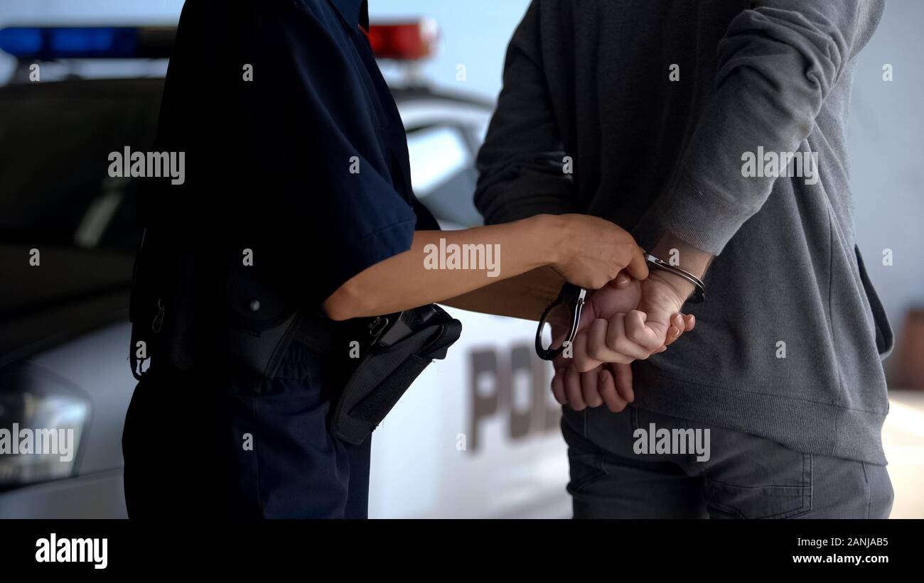 Police officer wearing handcuffs on dangerous criminal, detention on ...