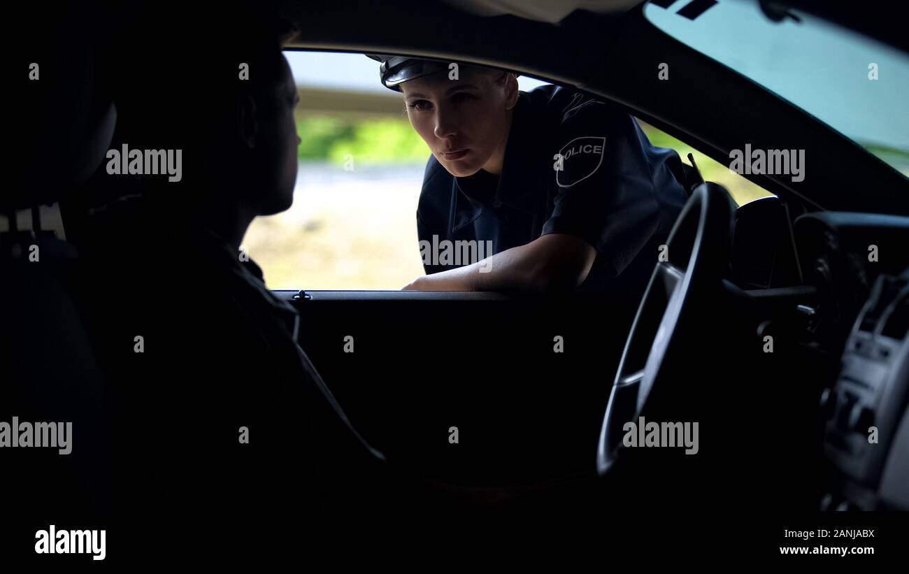 Police woman talking with driver in car, inspection on road, traffic ...