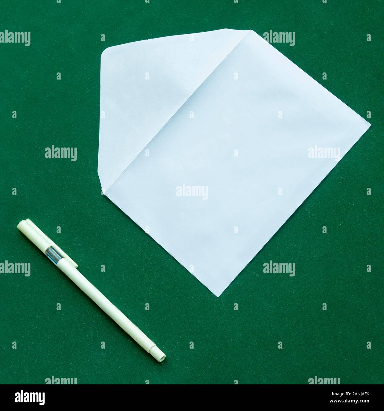 Traditional white letter envelope with ballpoint pen next to it, on a ...
