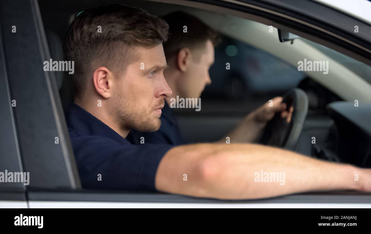 Male security guards sitting in car, monitoring safety, private ...