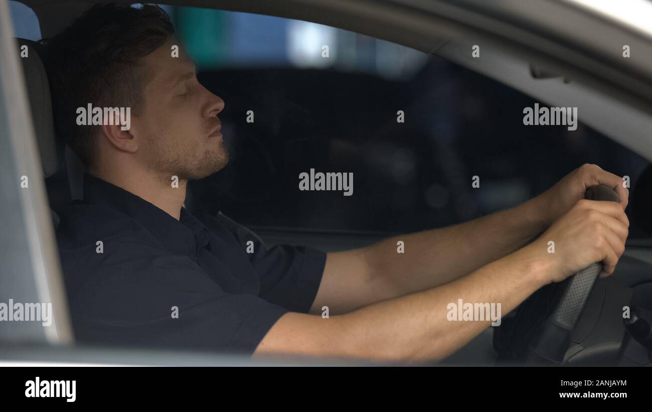 Tired police officer closed eyes sitting in car, exhausted after ...