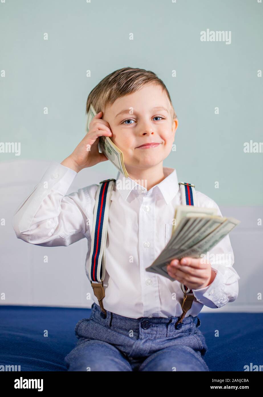 Cute baby boy playing with a lot of money like talking on telephone ...