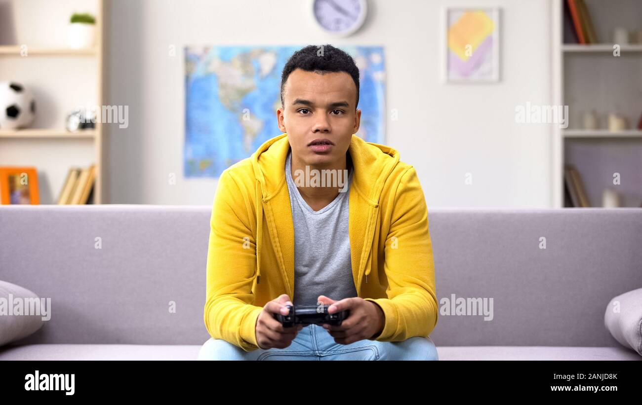 Addicted African-American teenager playing computer game, lack of ...