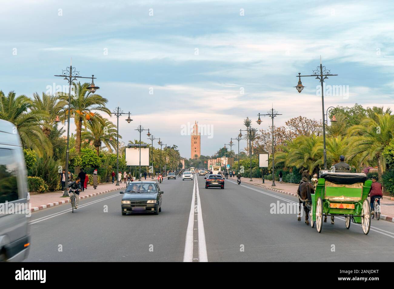 Regular car traffic on street leading to mosque - heart of Marrakech ...