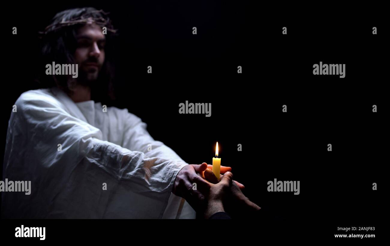 Savior supporting religious man holding candle, spiritual ritual, God ...