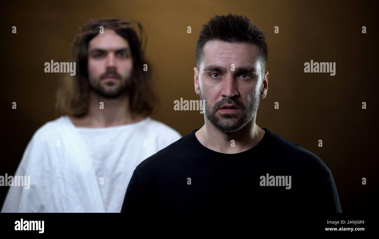 Sad man with messiah on background looking camera, spiritual support ...