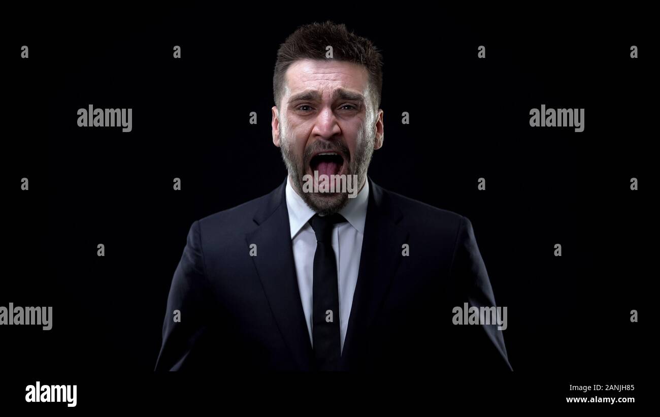 Shouting desperate employer on black background, nervous breakdown ...