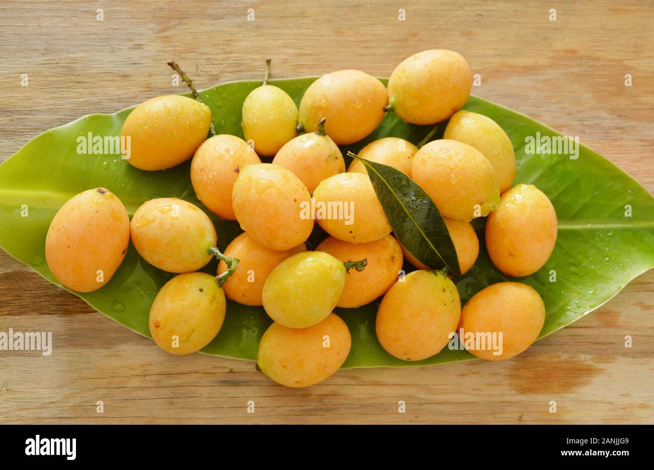 Marian plum tropical fruit produced in summer half cut on banana leaf ...