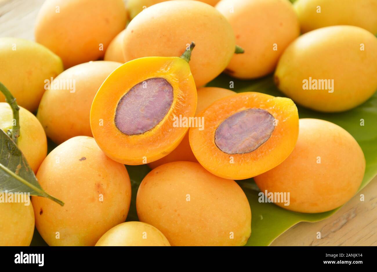 Marian plum tropical fruit produced in summer half cut on banana leaf ...