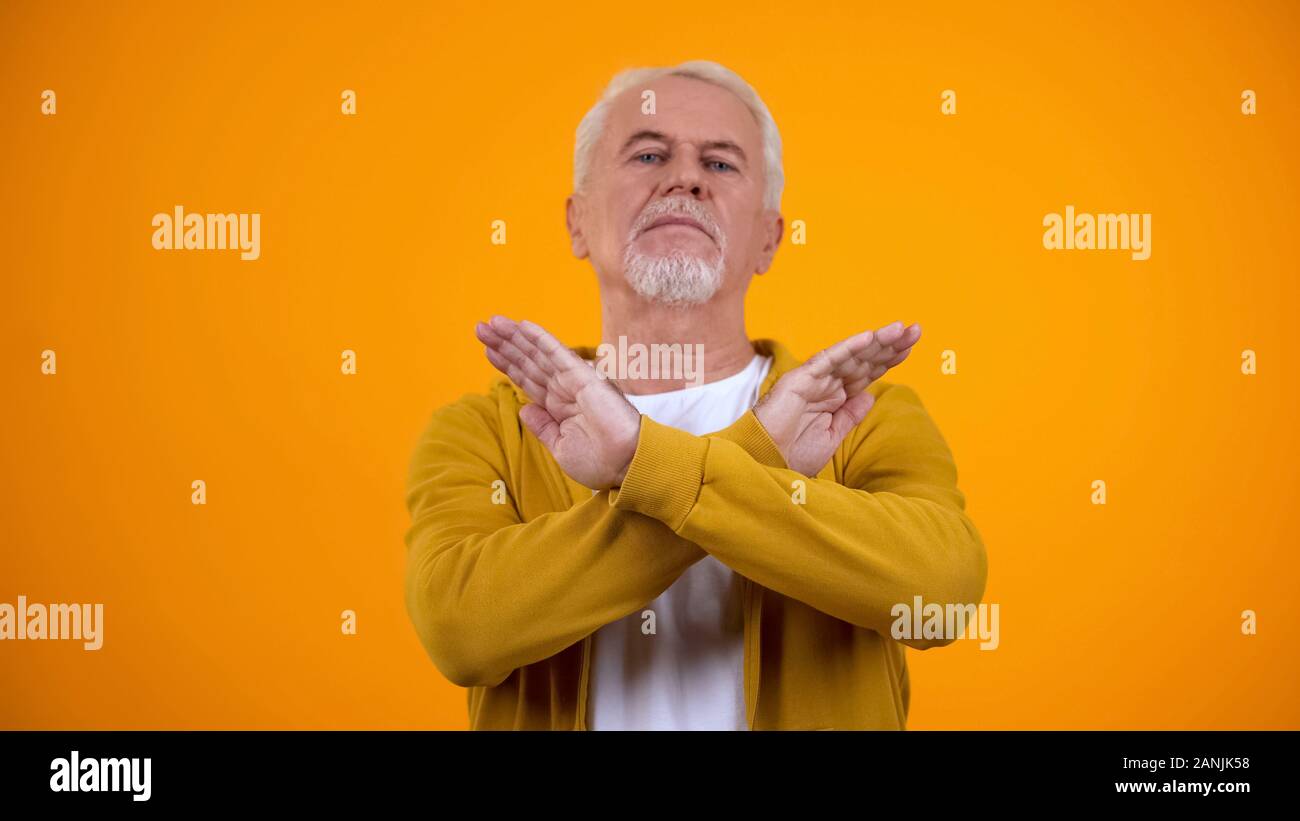 Dissatisfied old man crossing hands, rejecting bad service, stop sign ...