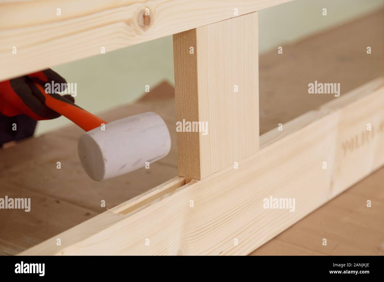 Assembling a wooden frame for a frame house. Hammer a frame element ...