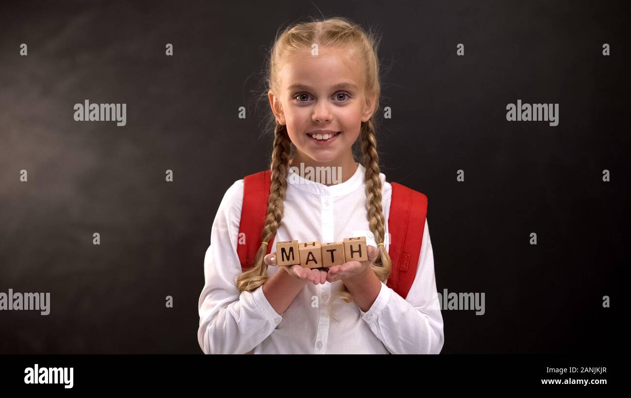 Math word on wooden cubes in cute schoolgirl hands, educational system ...