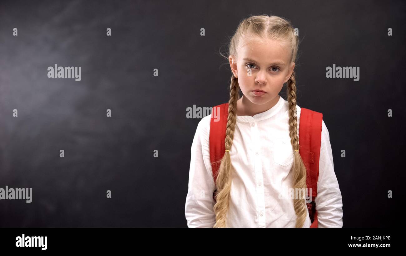 Unhappy pupil looking at camera, hating unloved school, problem child ...