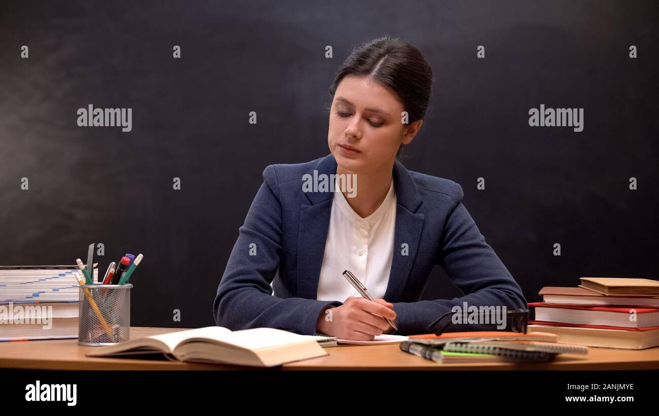 Tired teacher preparing for next lesson writing plan and additional ...