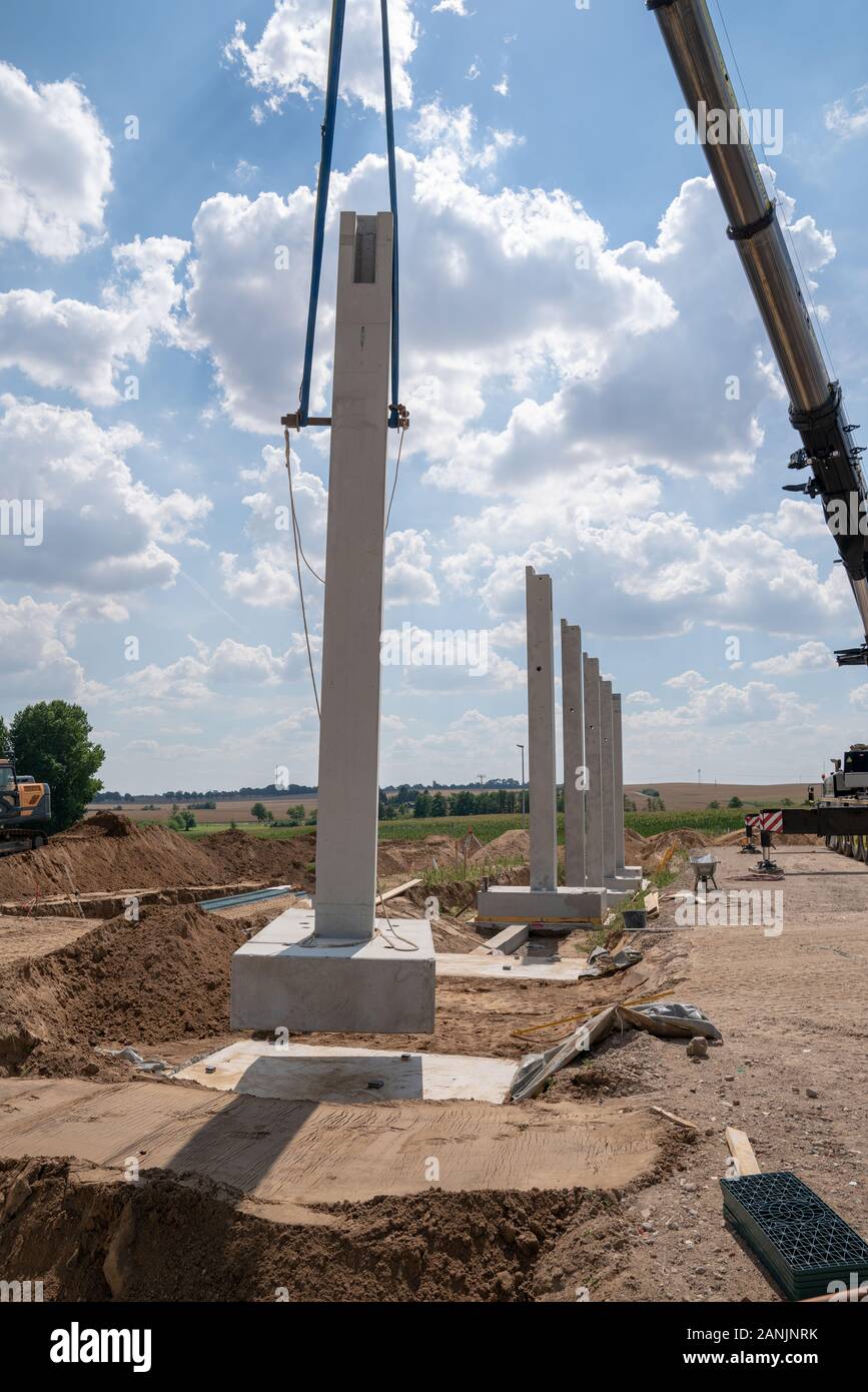 on a construction site, concrete columns for a factory building are ...